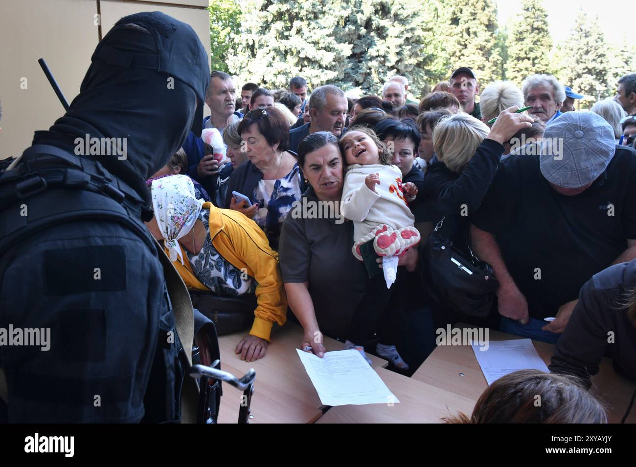 FILE - Evacuees line up to fill out forms at a humanitarian aid ...