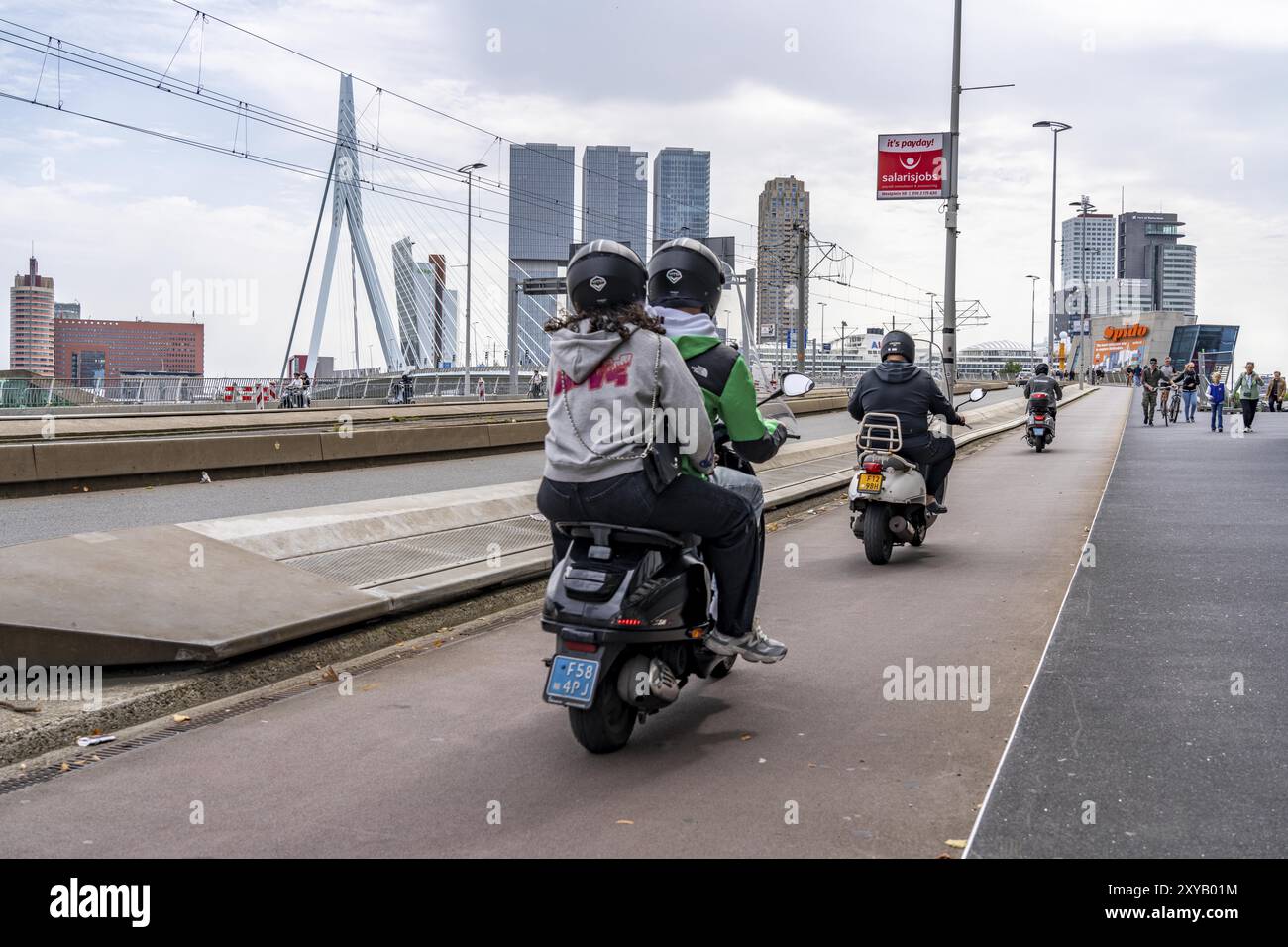 Scooter, cyclist on the cycle path of the Erasmus Bridge over the ...