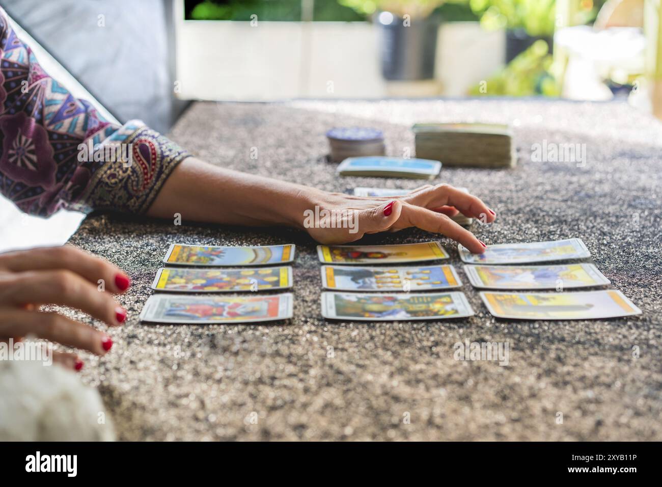 Side view of a tarot reader's hands reading the cards Stock Photo - Alamy