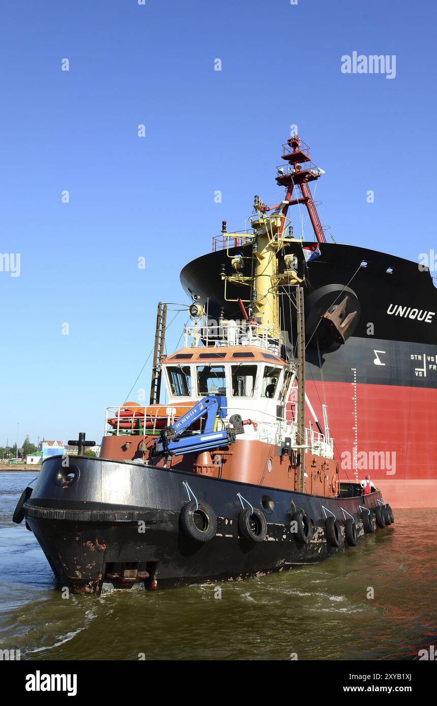 The oil tanker Unique Guaridan is towed in the harbour basin by a ...