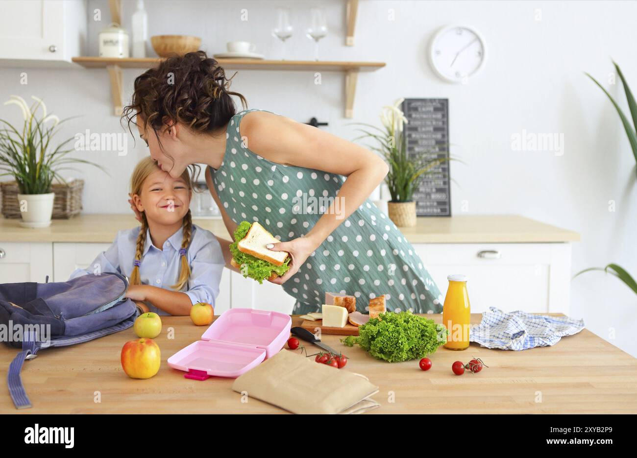 Beautiful brunette mother and her daughter packing healthy lunch and ...