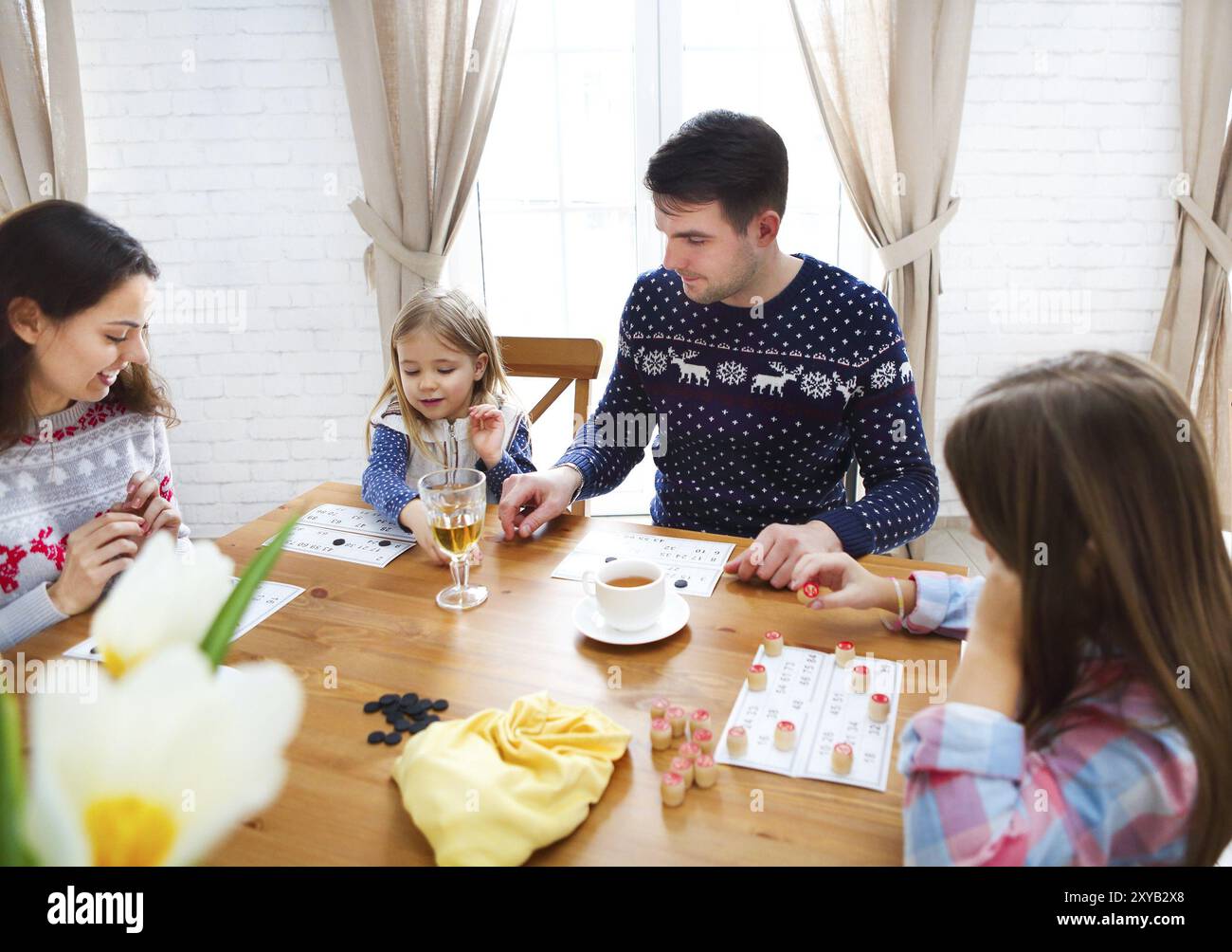 Happy young family plaing board game with two daughters Stock Photo - Alamy