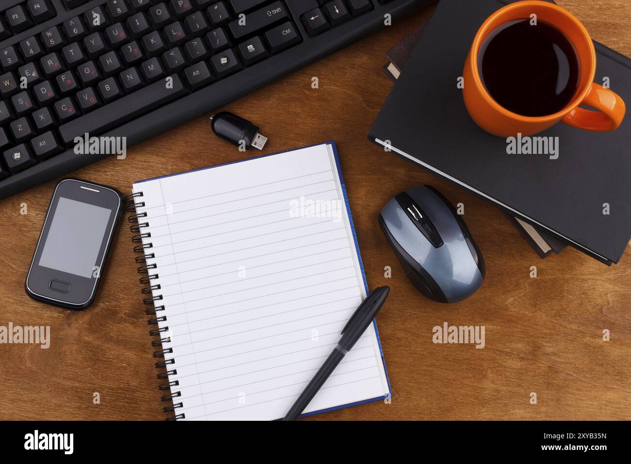 Overhead of office table with computer keyboard, mouse, smartphone, usb ...
