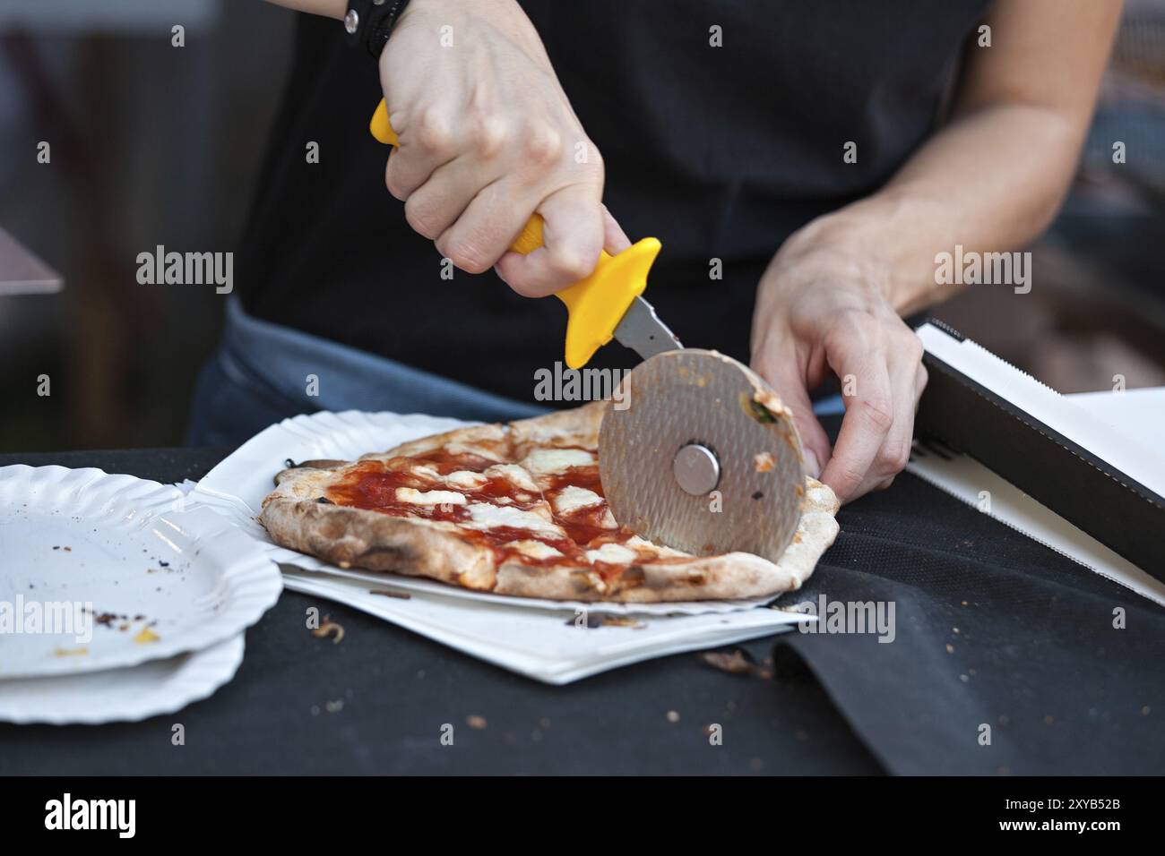Pizza maker cutting a pizza margherita in slices ready to takeaway Stock Photo - Alamy