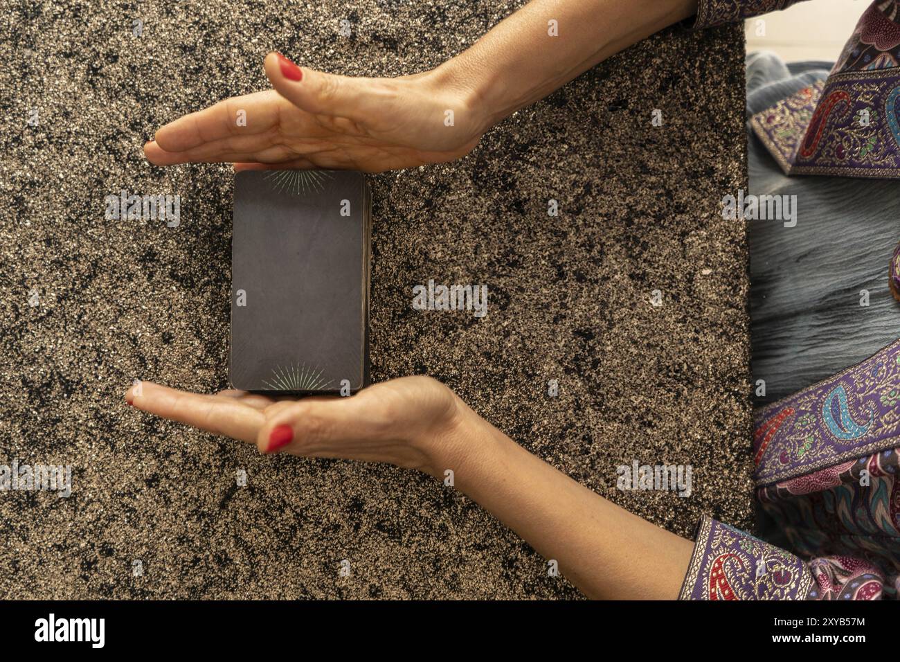Top view of a tarot reader's hands arranging the deck of tarot cards ...