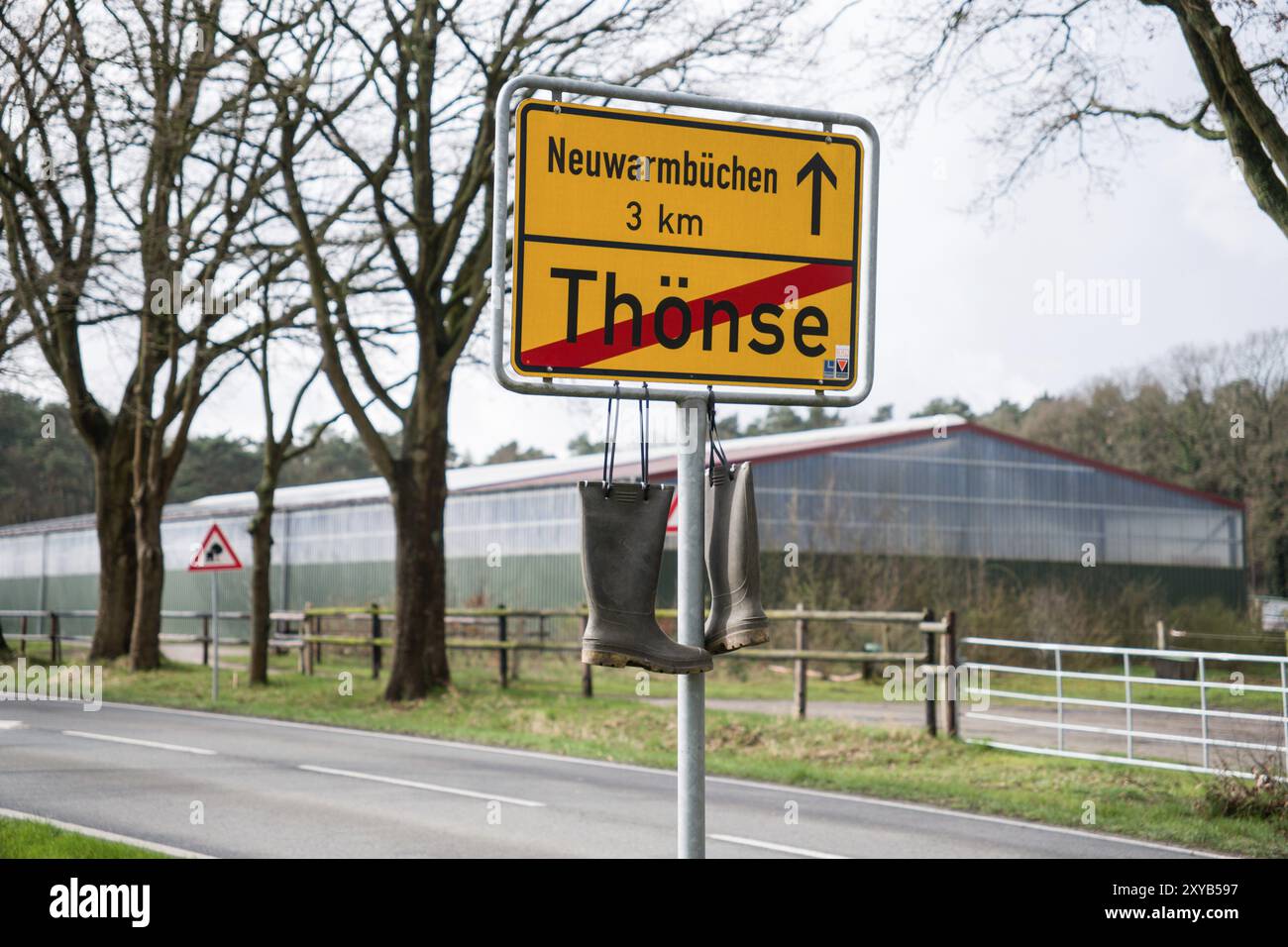 Rubber boots installed on a town exit sign Stock Photo - Alamy