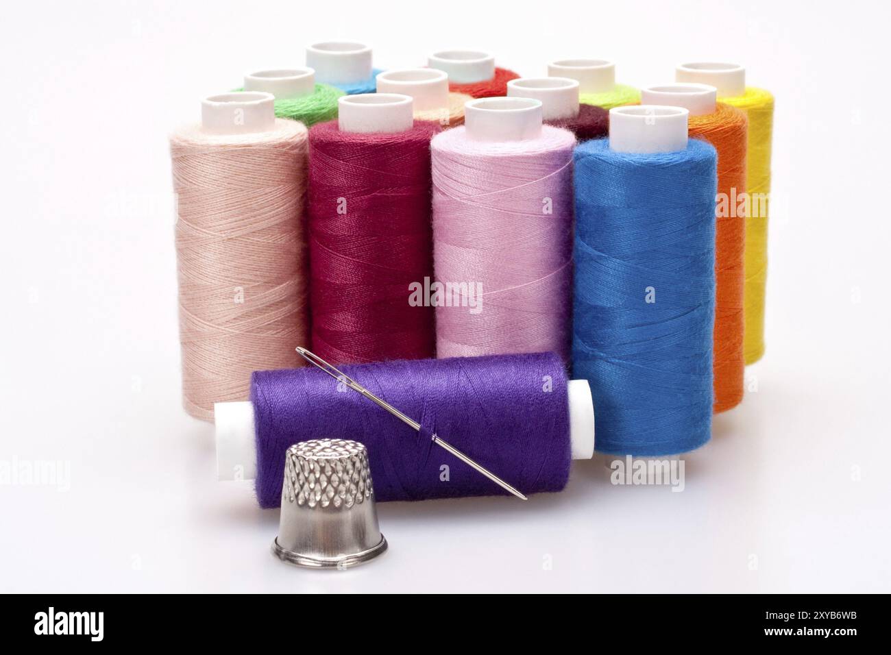 Multi-colored rainbow threads for sewing with needle and thimble Stock ...