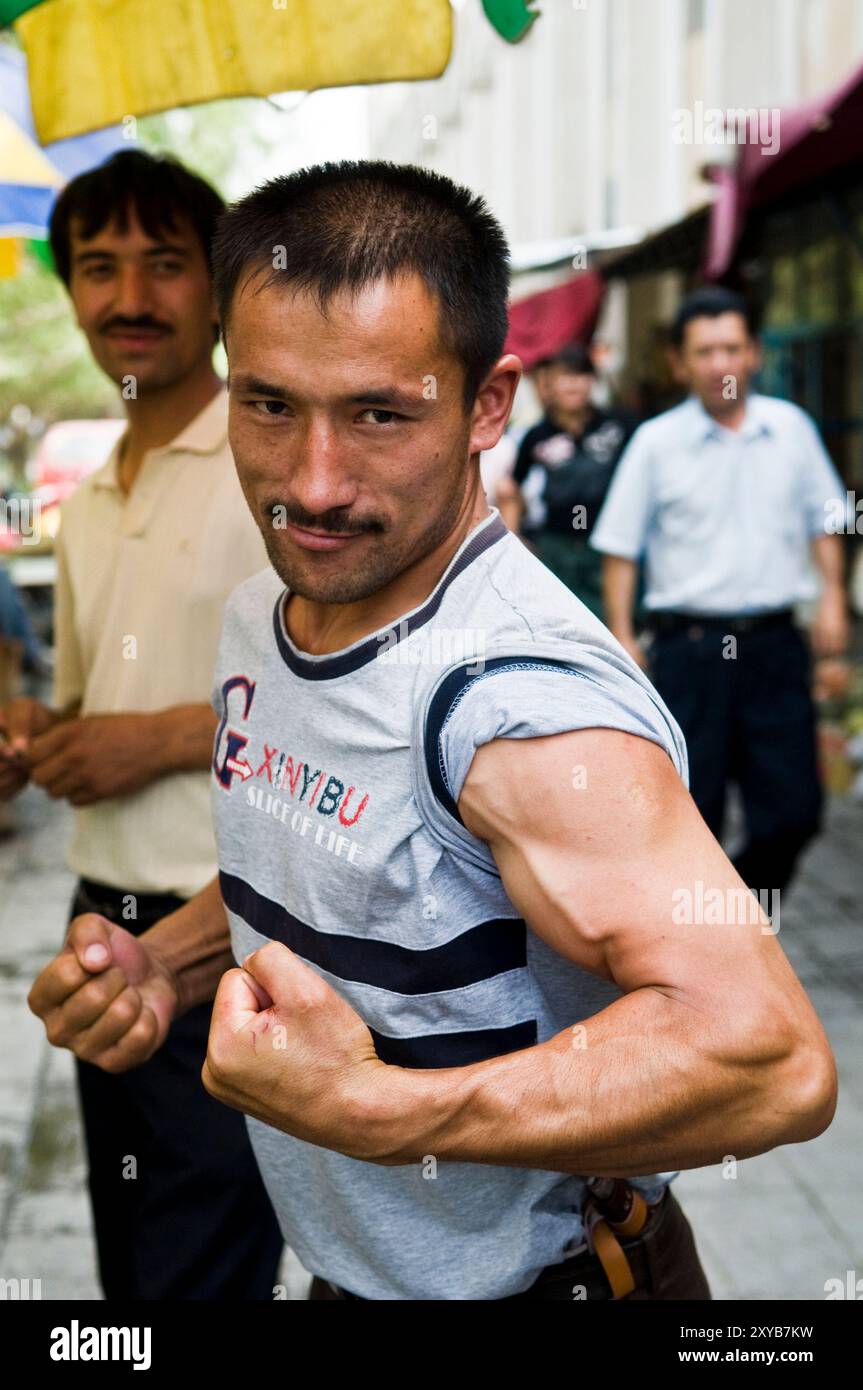 An Uyghur man showing off his arm muscles. Photo taken in Kashgar ...