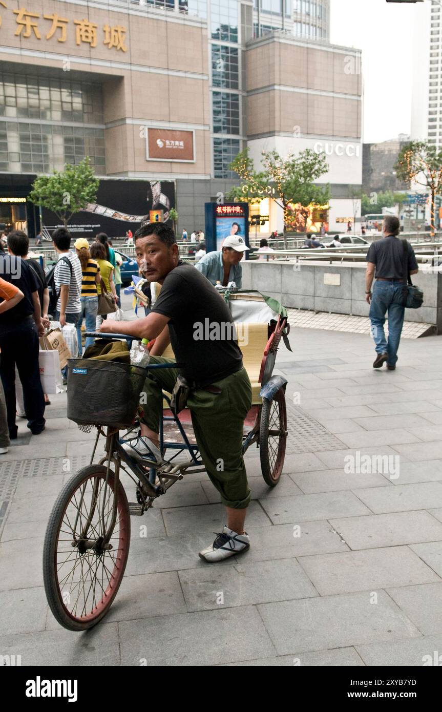 Cycle rickshaw in the middle of the modern commercial center of Nanjing ...
