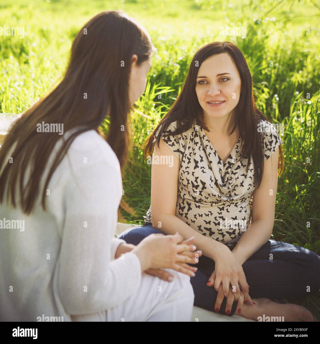 Portrait of two brunette women at picnic in the spring park Stock Photo ...