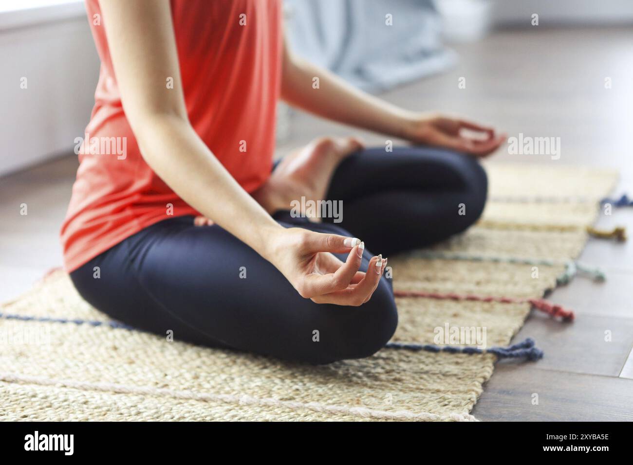Attractive young brunette woman exercising and sitting in yoga lotus ...
