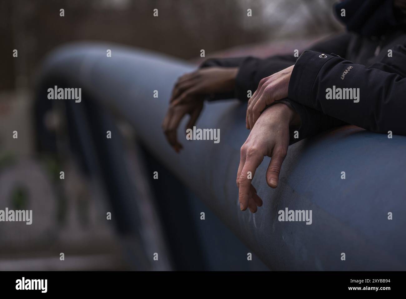 Two people place their hands relaxed on a railing Stock Photo - Alamy