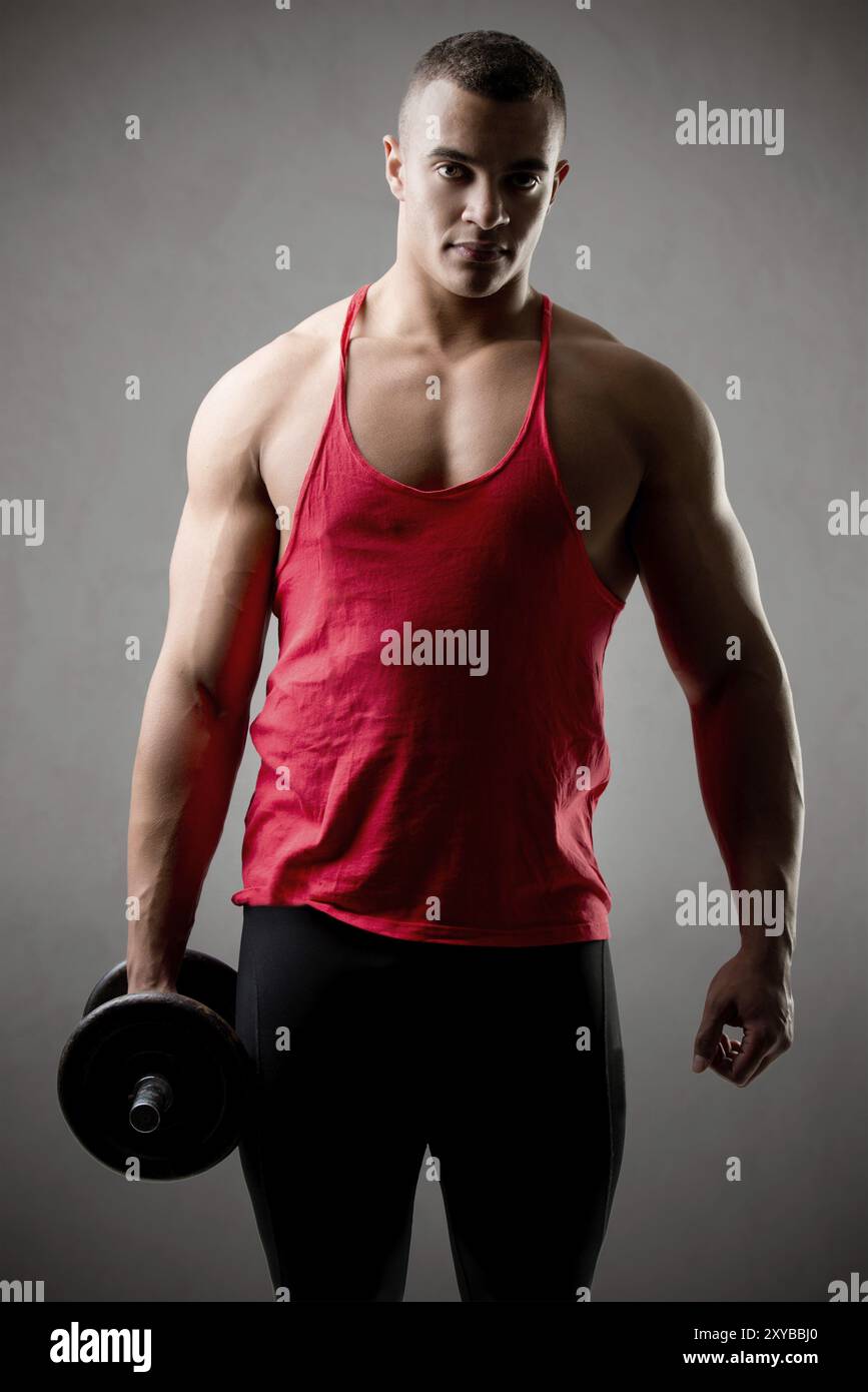 Fit athlete doing standing dumbbell curls for training his biceps ...