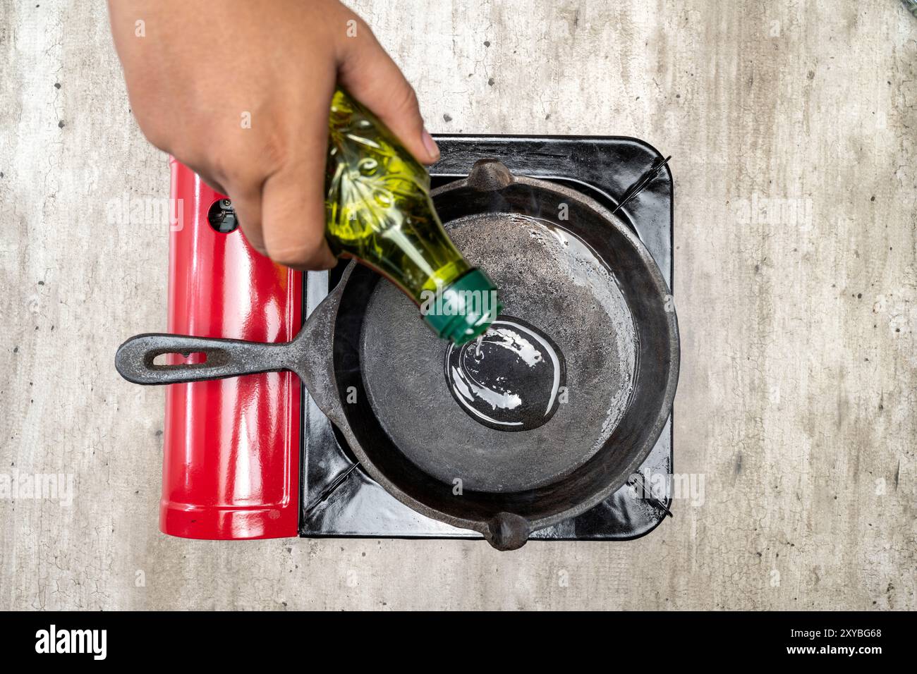Hand pouring oil skillet hi-res stock photography and images - Alamy