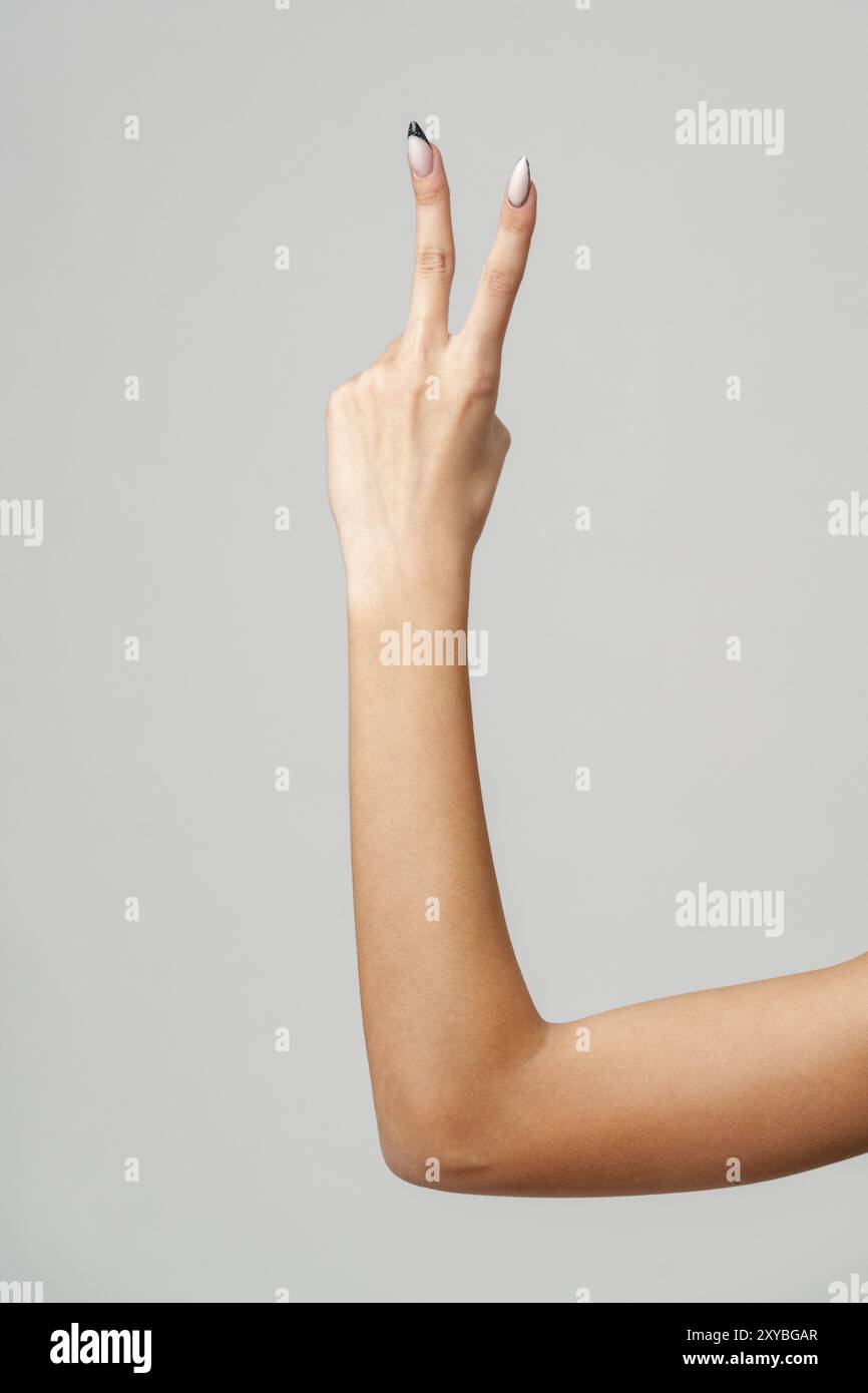 Woman's Hand Making Peace Sign With Long, White Nails Against Grey ...