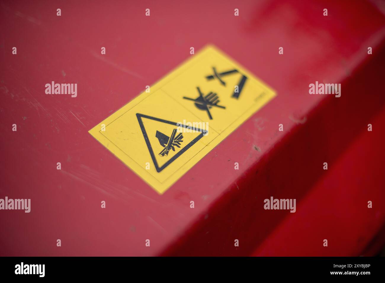 Yellow warning label on a red lawn mower Stock Photo - Alamy