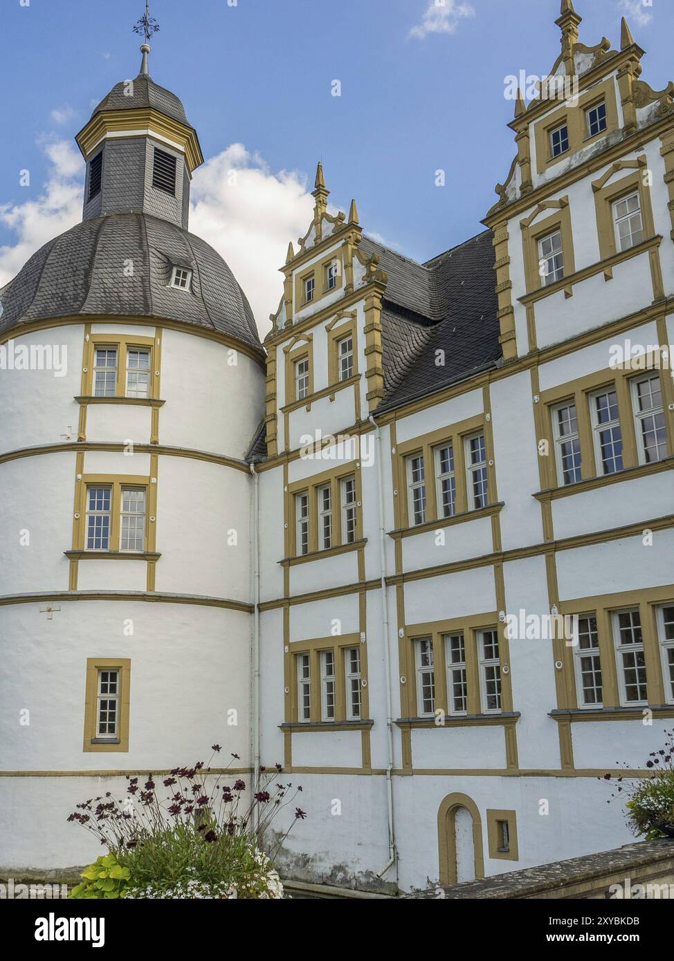 Baroque castle with tower and many windows under a blue sky, surrounded ...