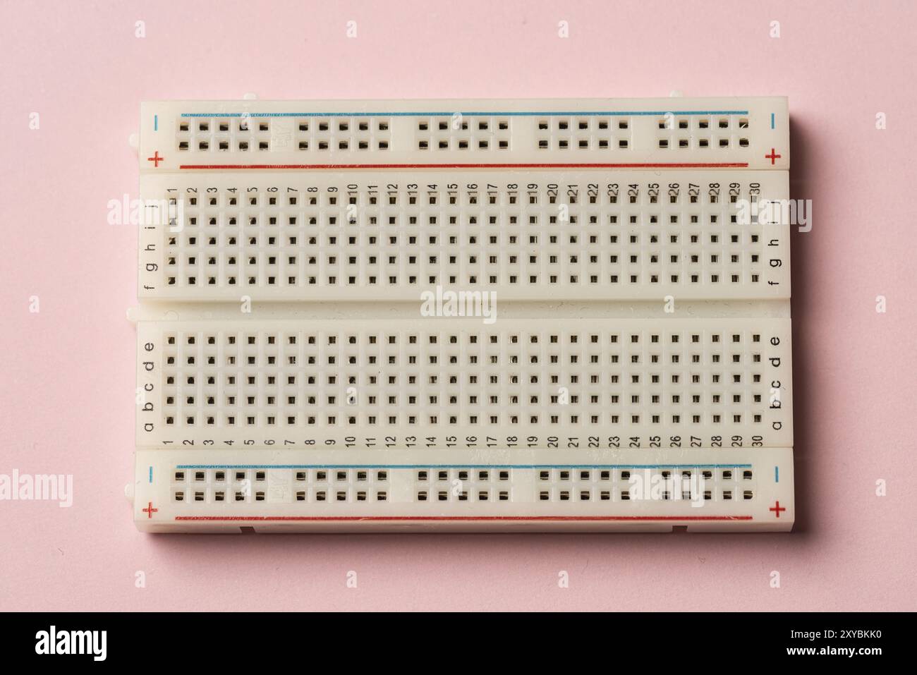 An electronics breadboard on pink background Stock Photo - Alamy