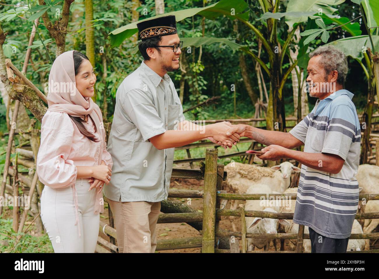 Happy Asian Muslim couple doing handshake gesture with the cattleman ...