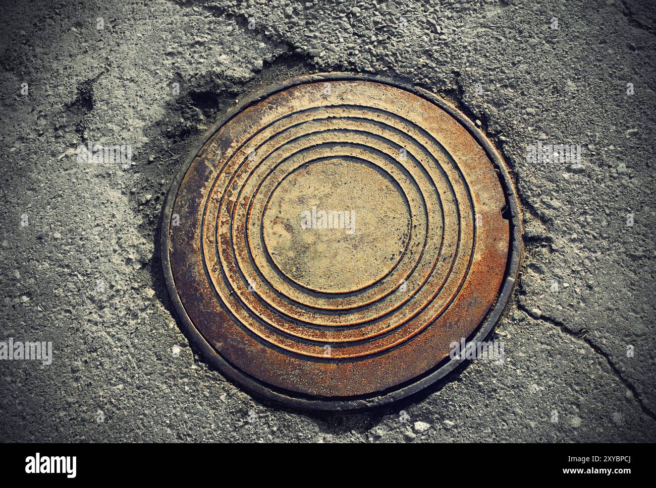Rusty round manhole on the broken asphalt Stock Photo - Alamy