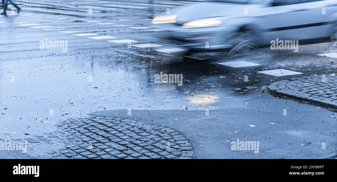 A grey car driving through a puddle of water Stock Photo - Alamy
