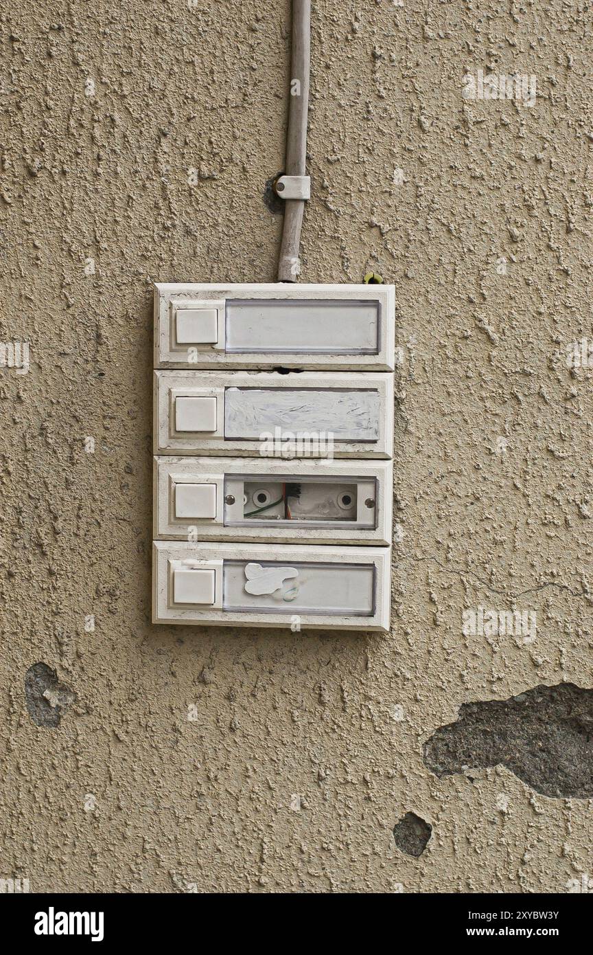 Four old and worn door bells on a beige wall Stock Photo - Alamy