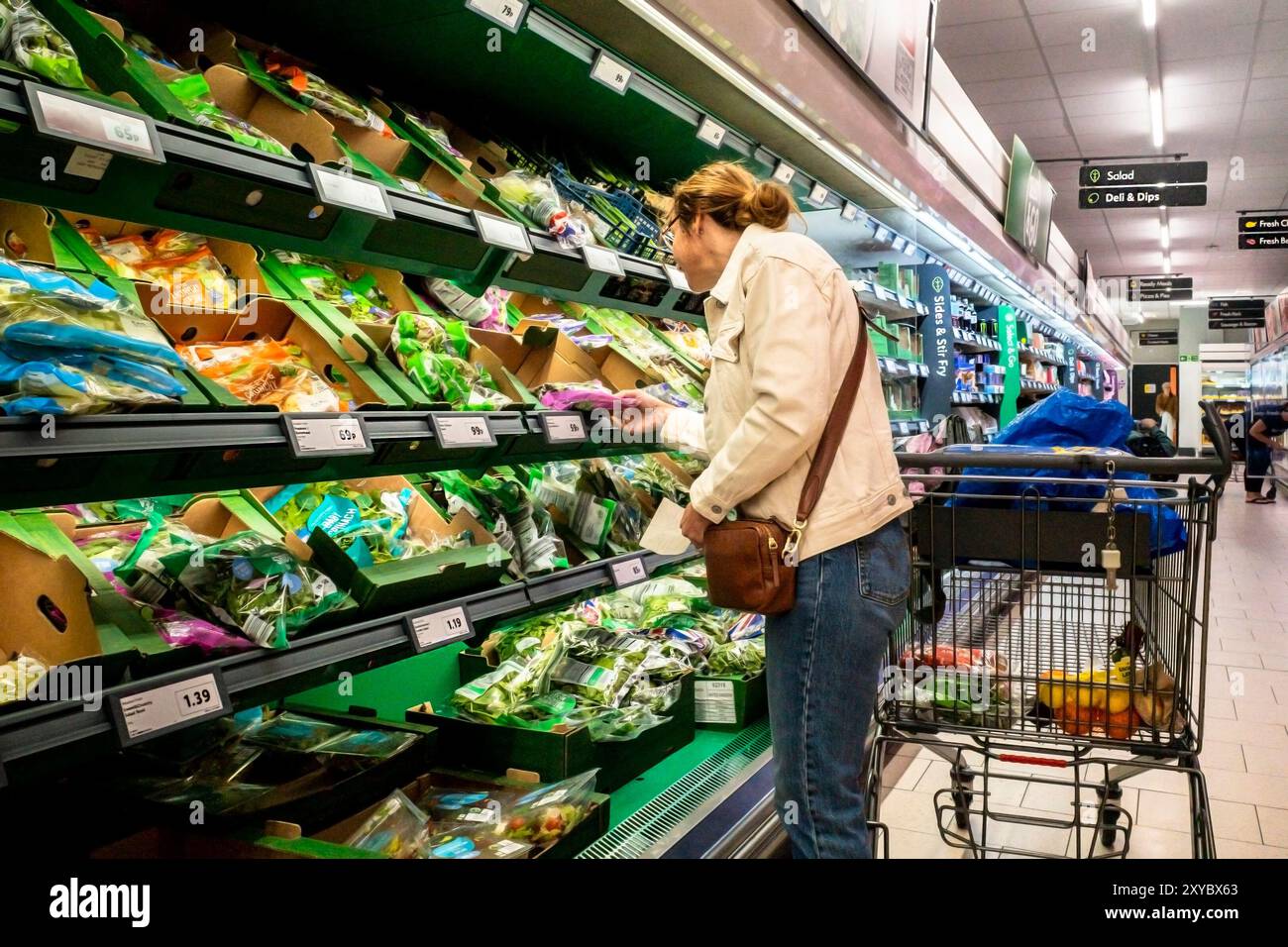 A shopper person woman female buying fresh vegetables inside a Lidl ...