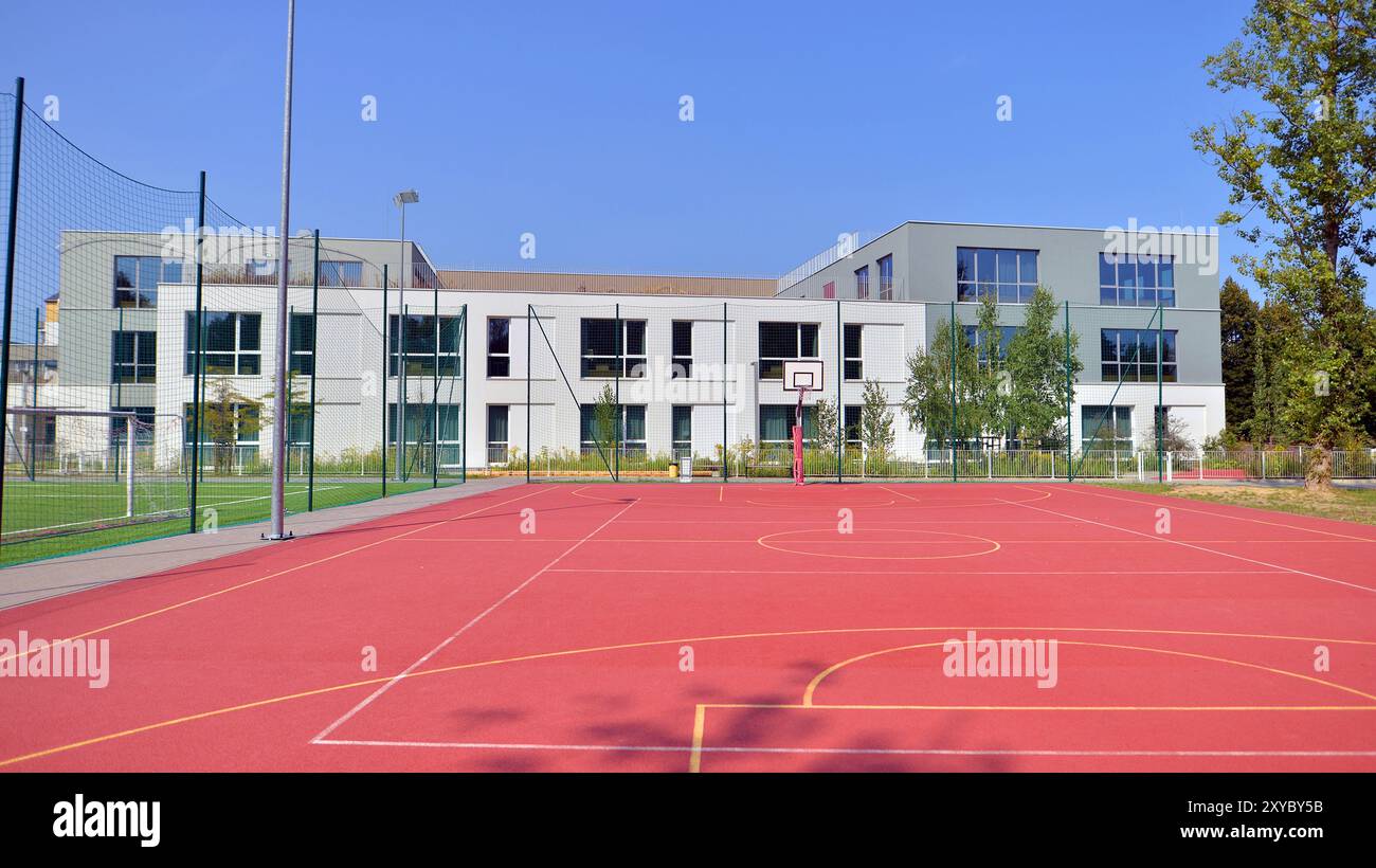 Schoolyard with basketball court and school building exterior in the ...