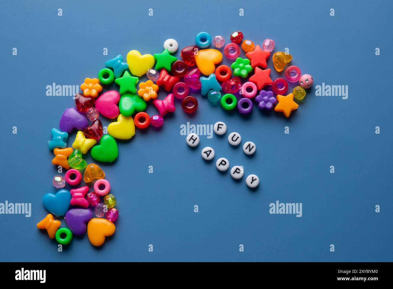 A collection of colorful beads is spread out across a blue background ...