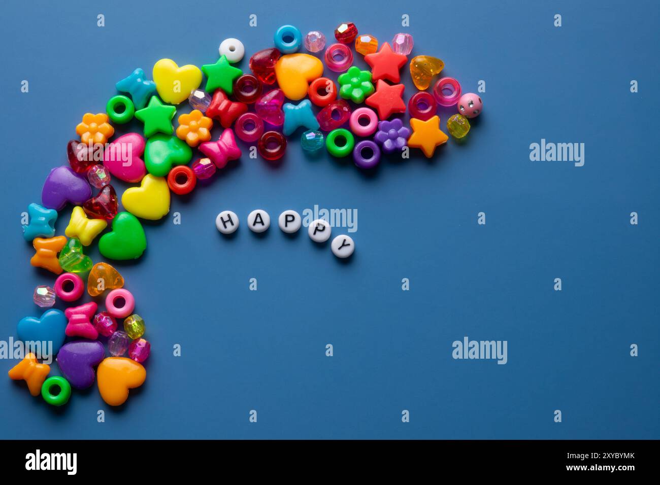 A collection of colorful beads is spread out across a blue background ...