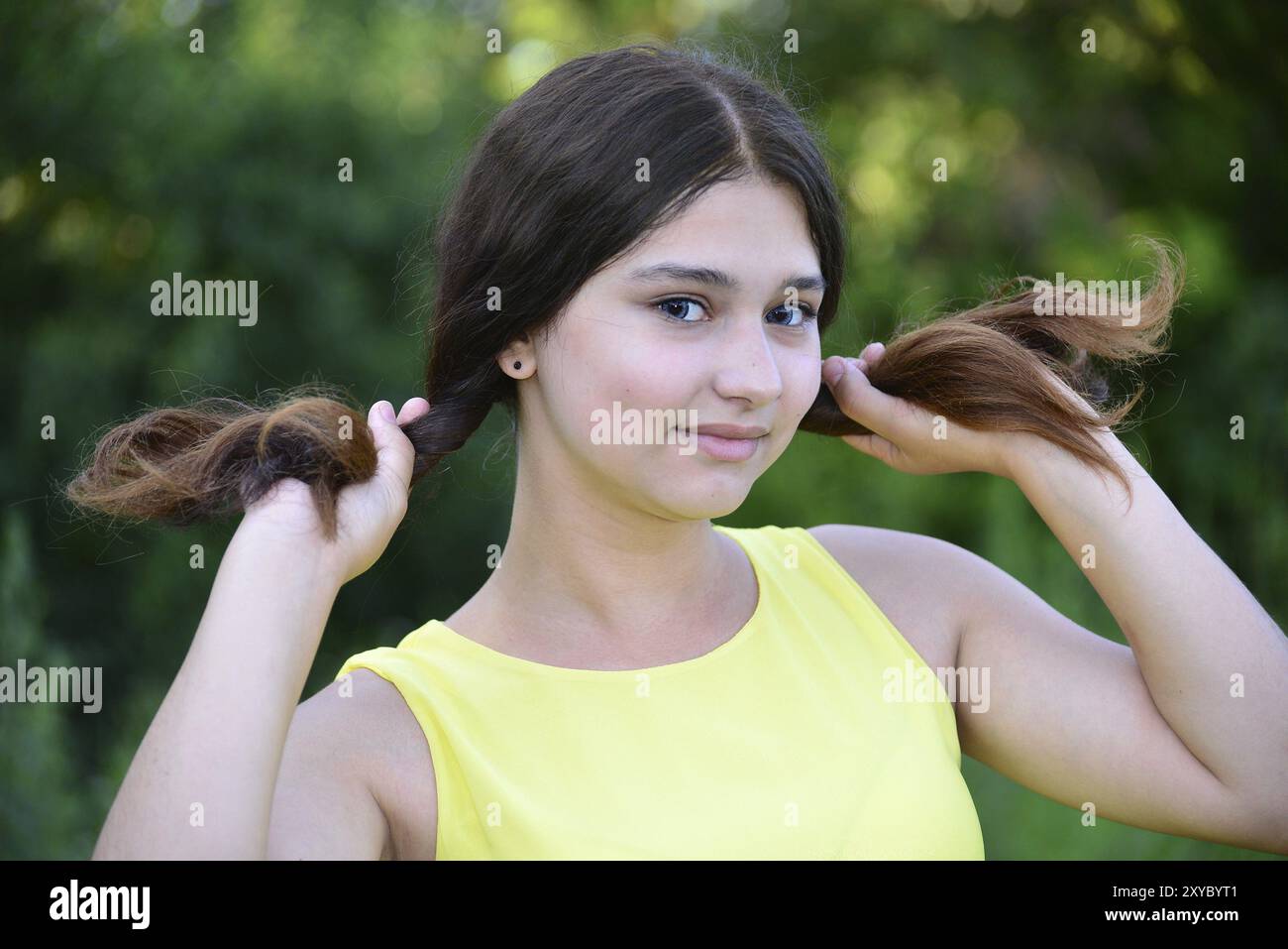 The girl holds her hands hair on nature Stock Photo - Alamy