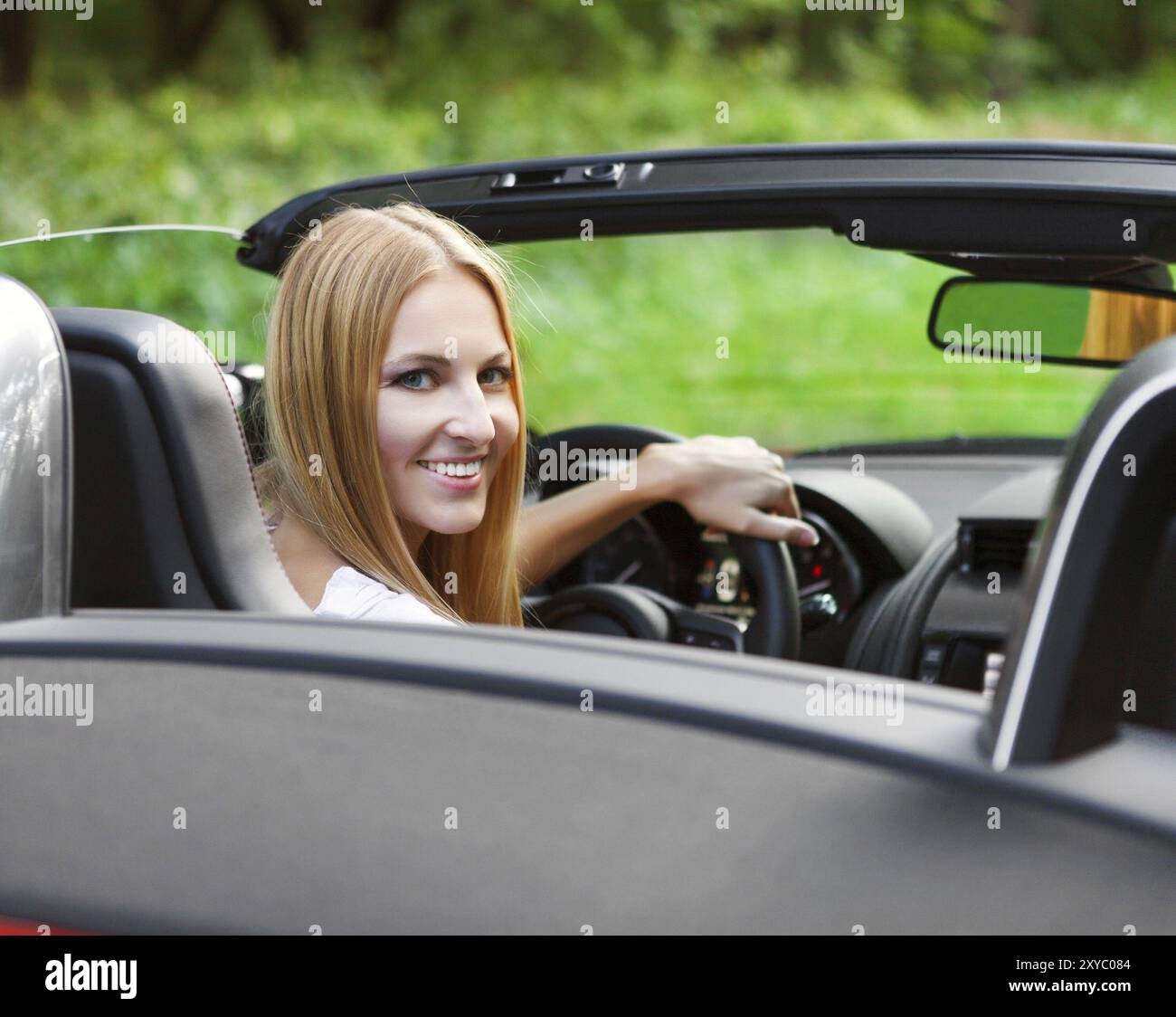 Beautiful blond young woman driving a sports car Stock Photo - Alamy