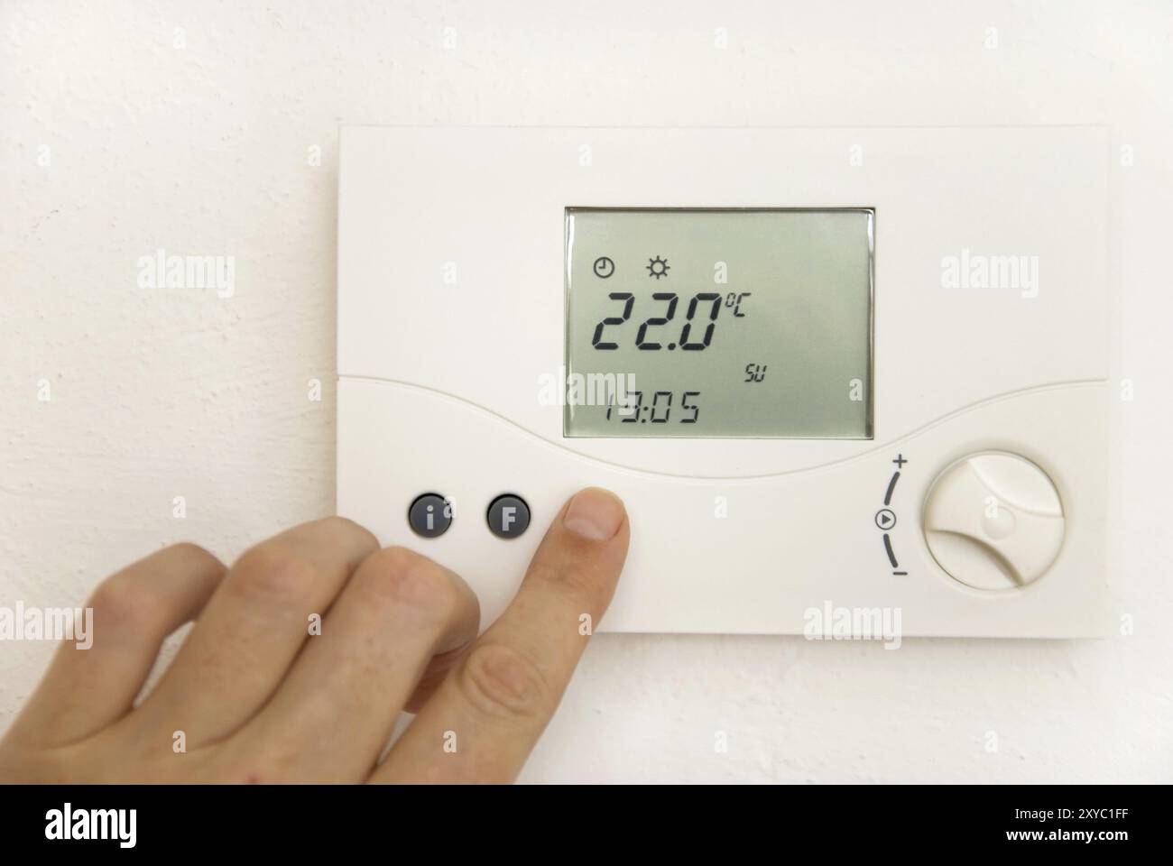 Hand adjusting temperature at thermostat Stock Photo - Alamy