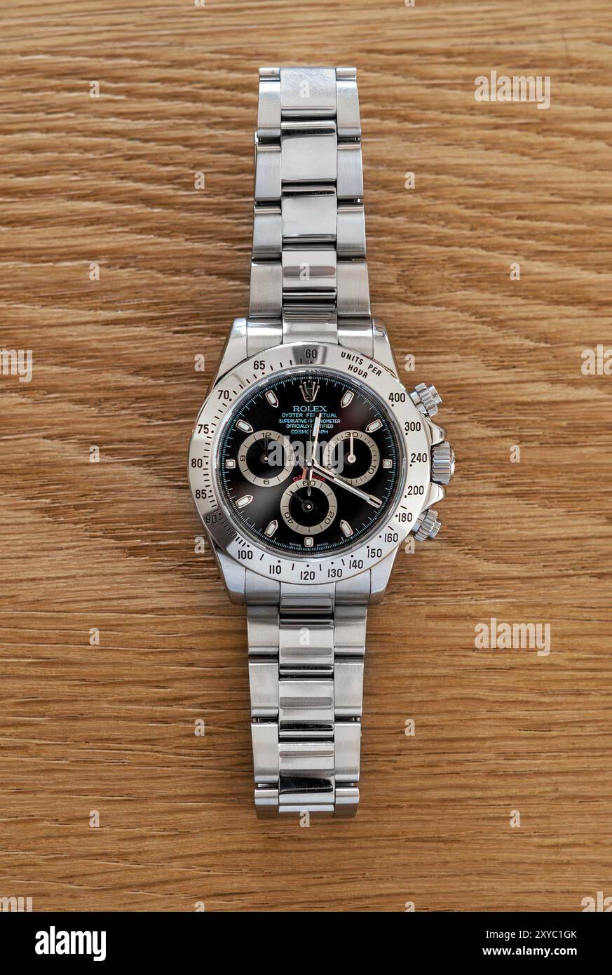 Stainless steel Rolex Daytona chronograph wristwatch on a wooden desk ...