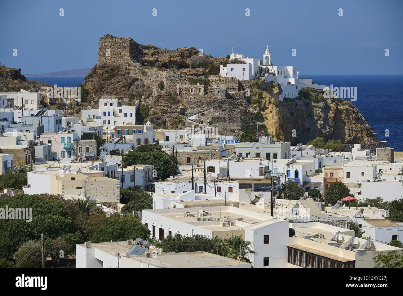 Whitewashed buildings and a historic castle stretch across a rocky hill ...
