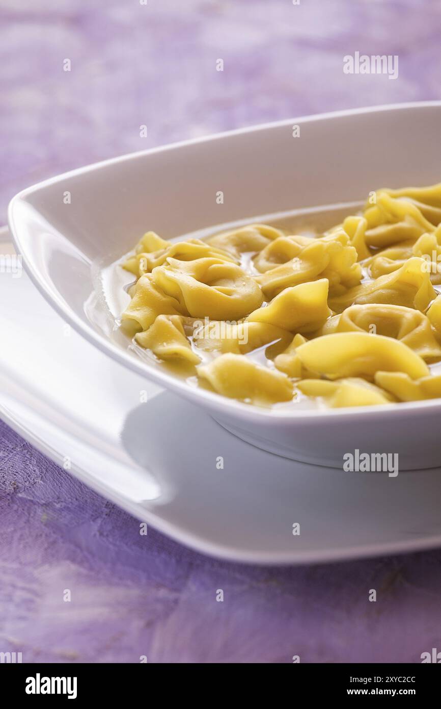 Tortellini in broth in a white square plate Stock Photo - Alamy