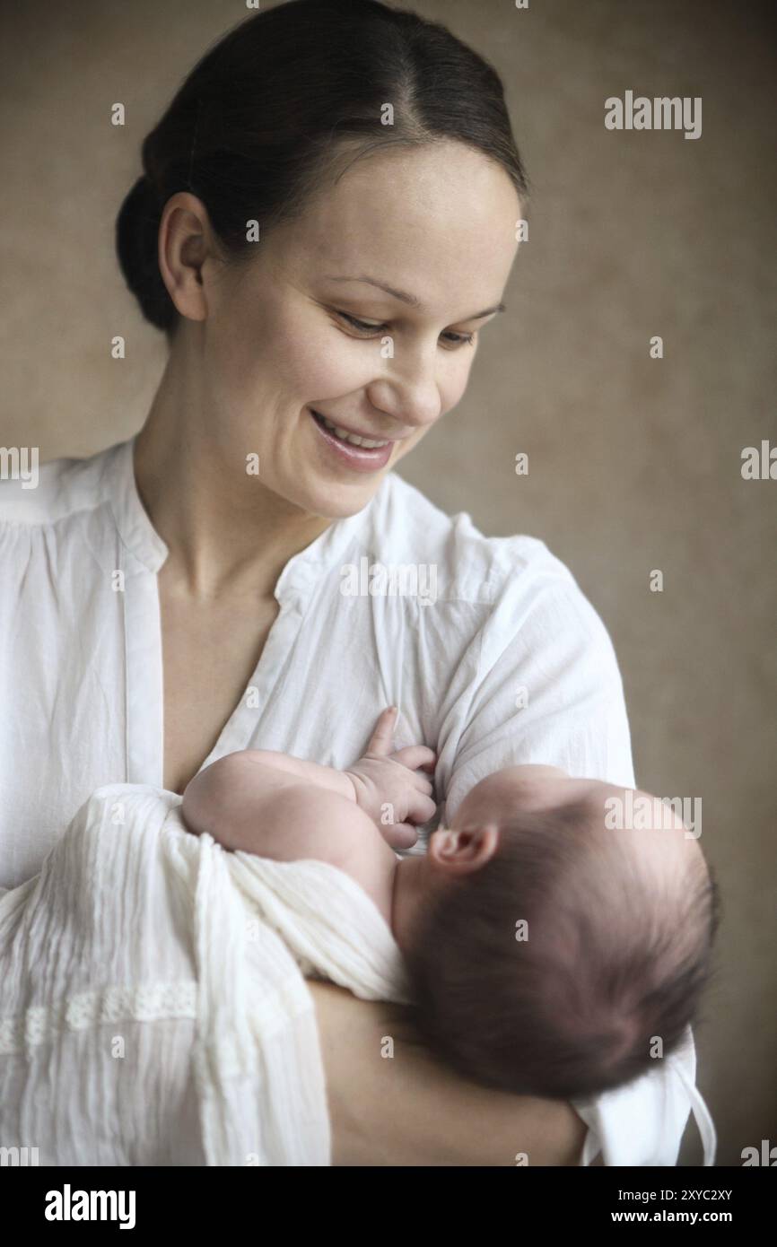 One month old baby boy falling asleep in the arms of her mother Stock ...
