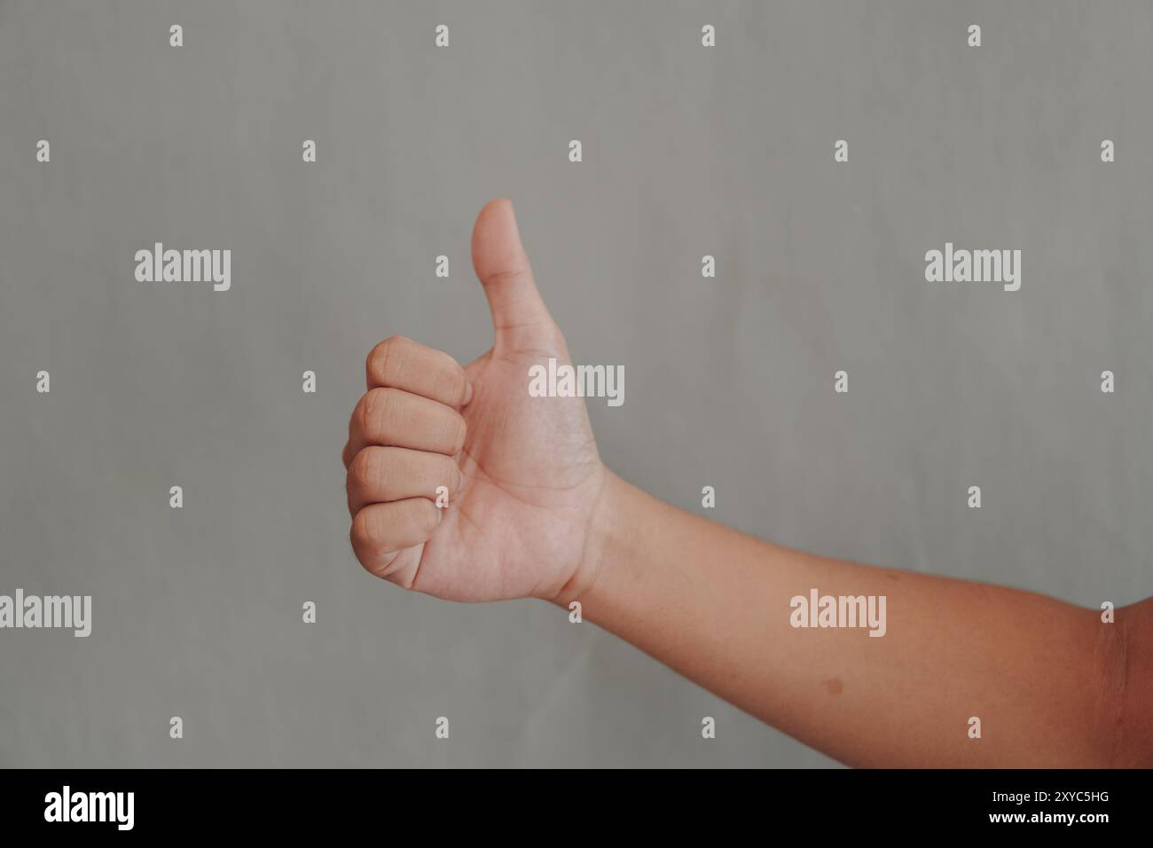 A hand is giving a thumb up approval gesture. Concept of approval or ...