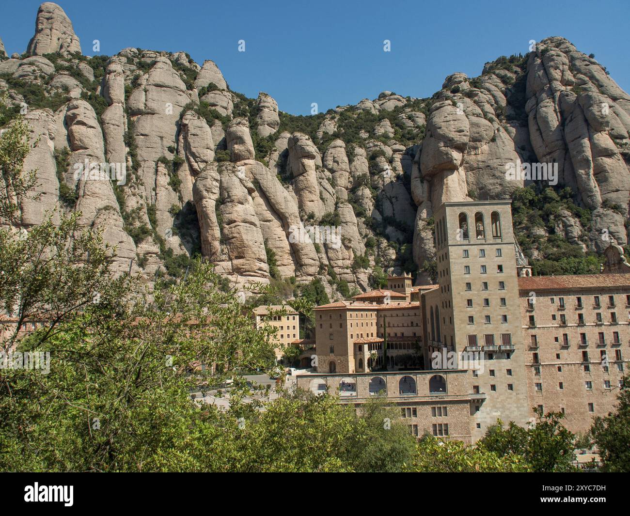 A historic monastery in front of majestic cliffs and a deep blue sky ...