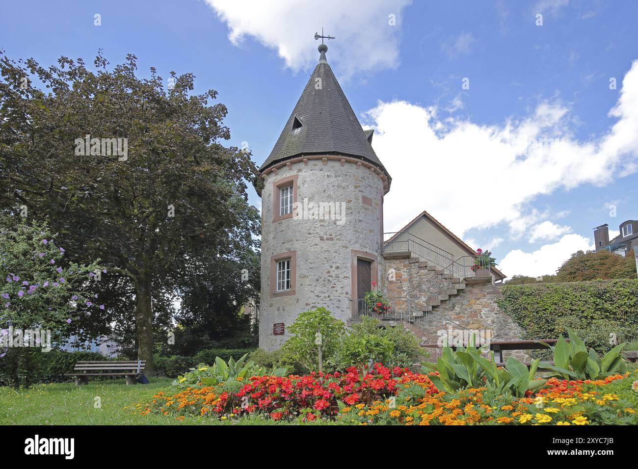Historic stag tower built in 1330, town tower, empty bench, flower bed ...
