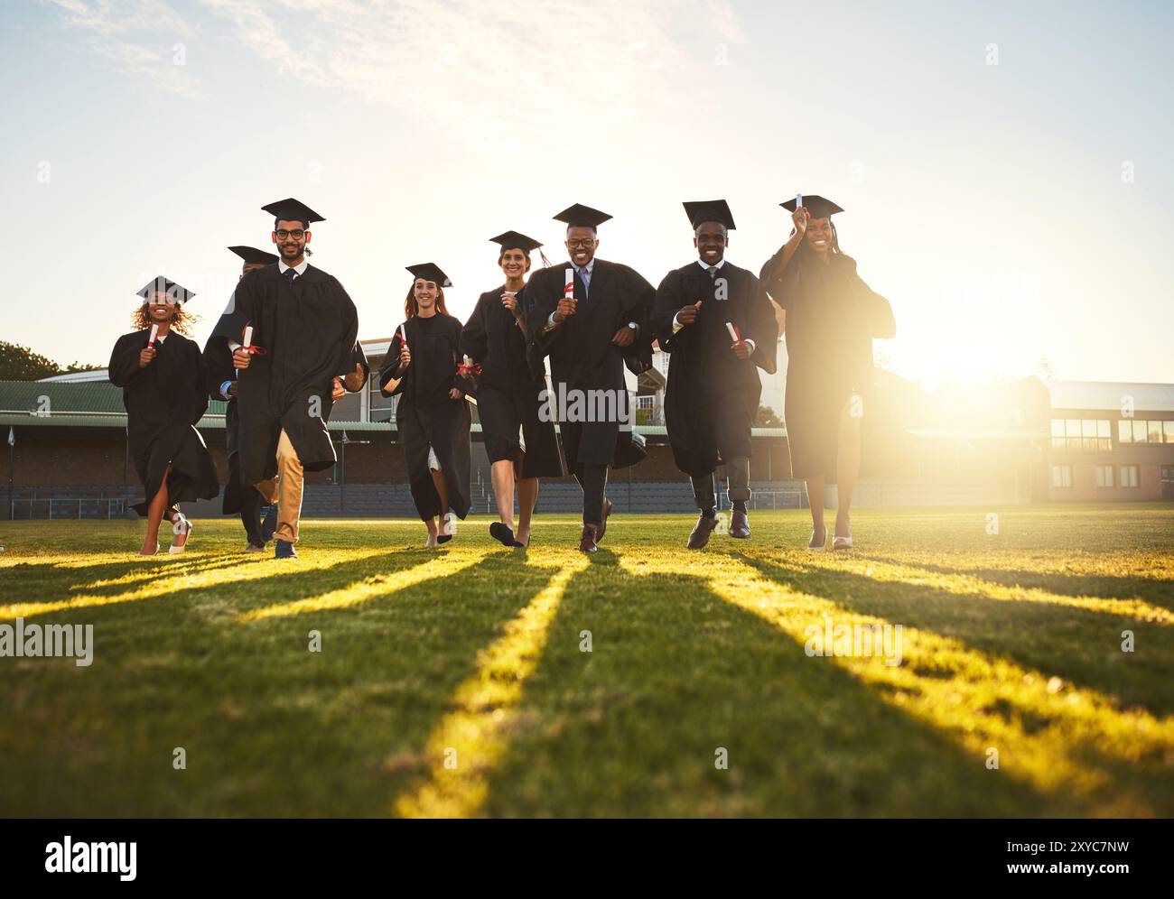 Graduation, group running and campus lawn with college success, student ...