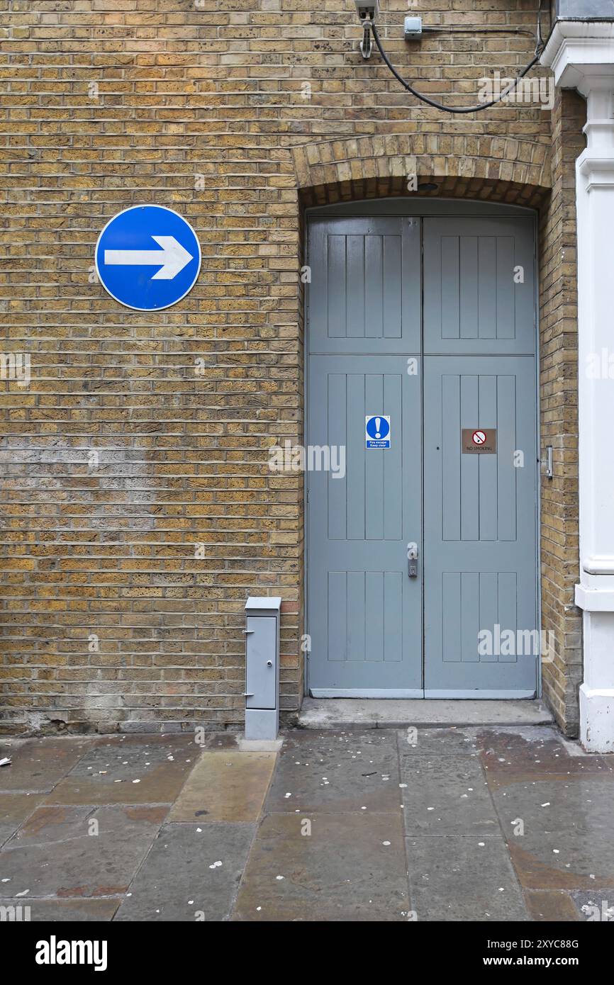 Directional Arrow Traffic Sign at Yellow Brick Wall Large Double Doors ...