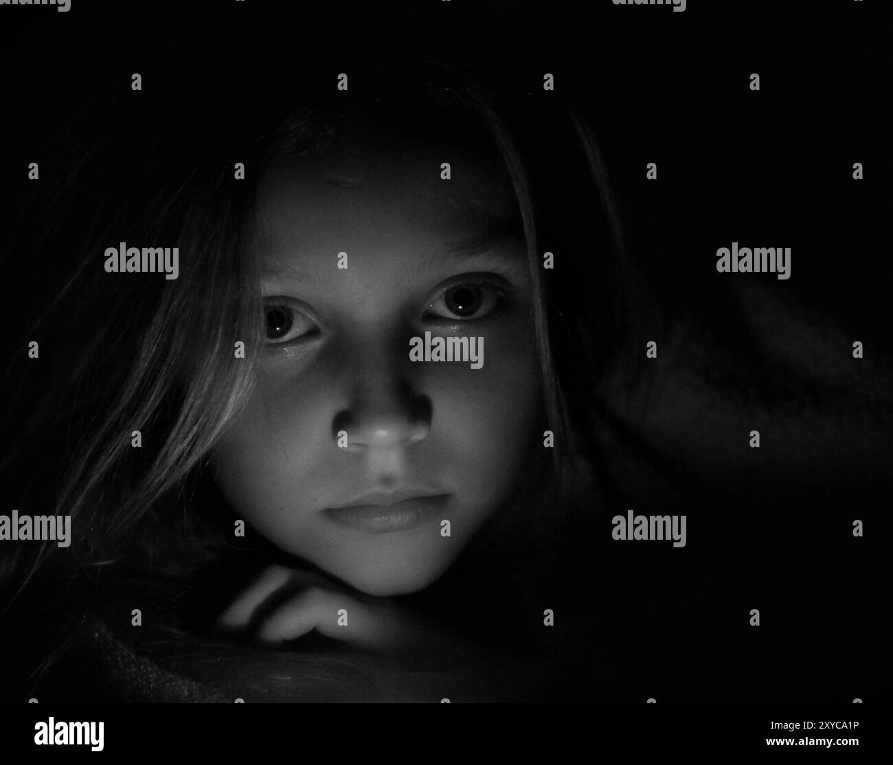 close up of a face of a little sad girl resting her head on her hands ...