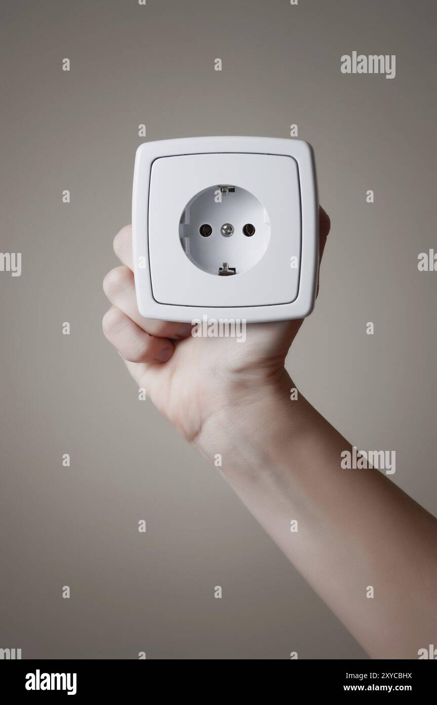 Hand holding an electric outlet Stock Photo - Alamy