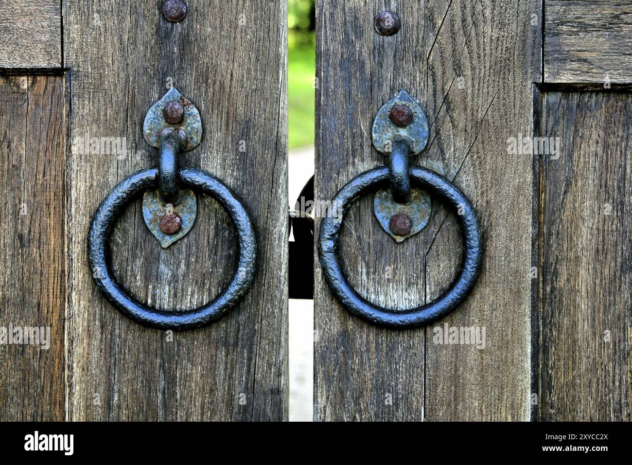 Ancient wooden gate with two door knocker rings close-up Stock Photo ...