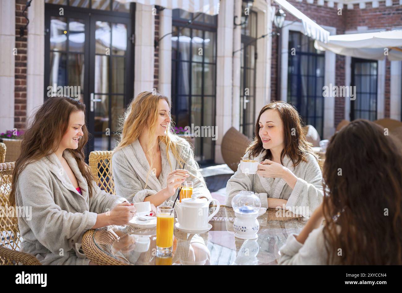 Four happy young women drinking tea at spa resort Stock Photo - Alamy