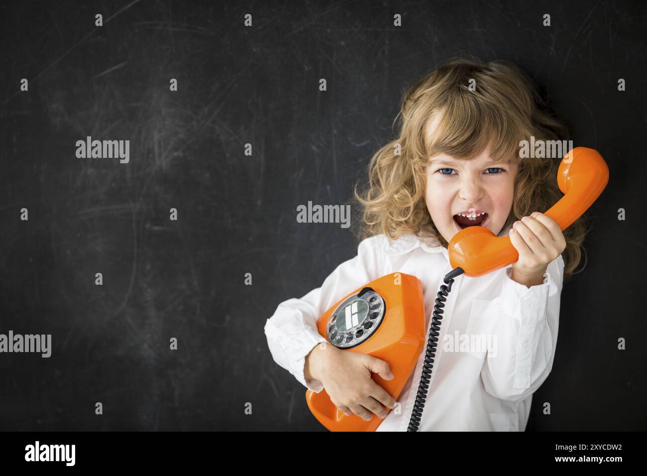 Aggressive kid calling by vintage phone Stock Photo - Alamy