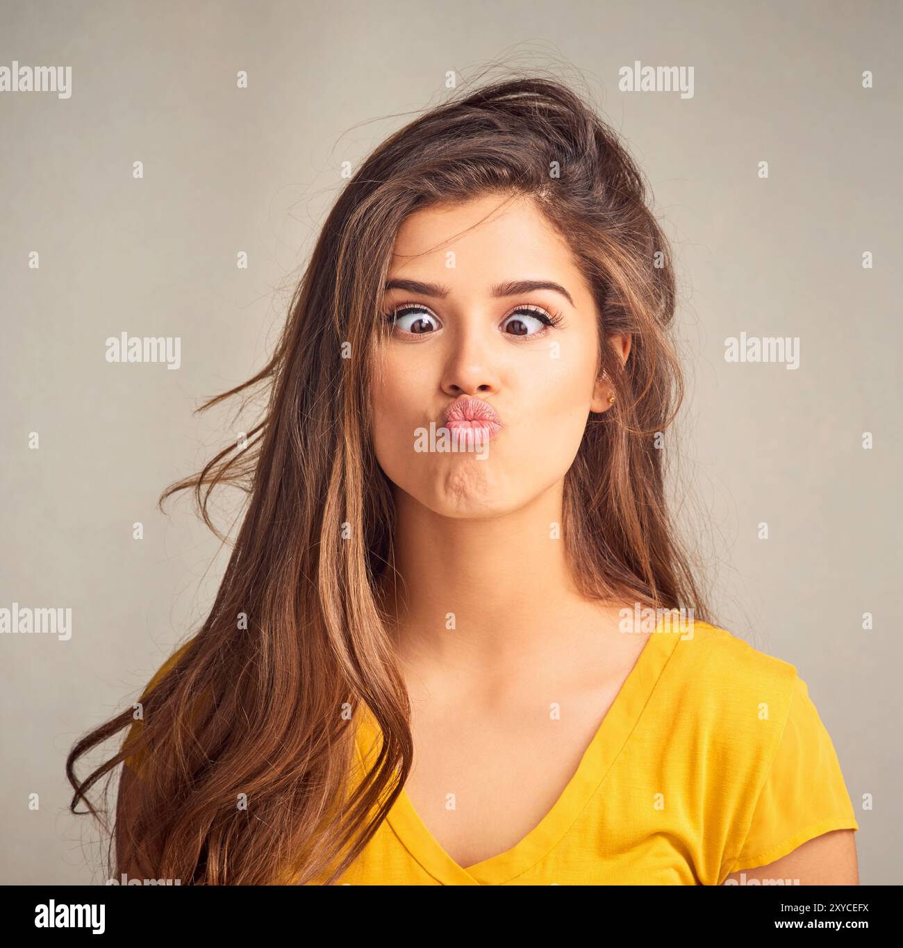 Pout, silly and face of woman in studio with crossed eyes for emotion, facial expression and ...