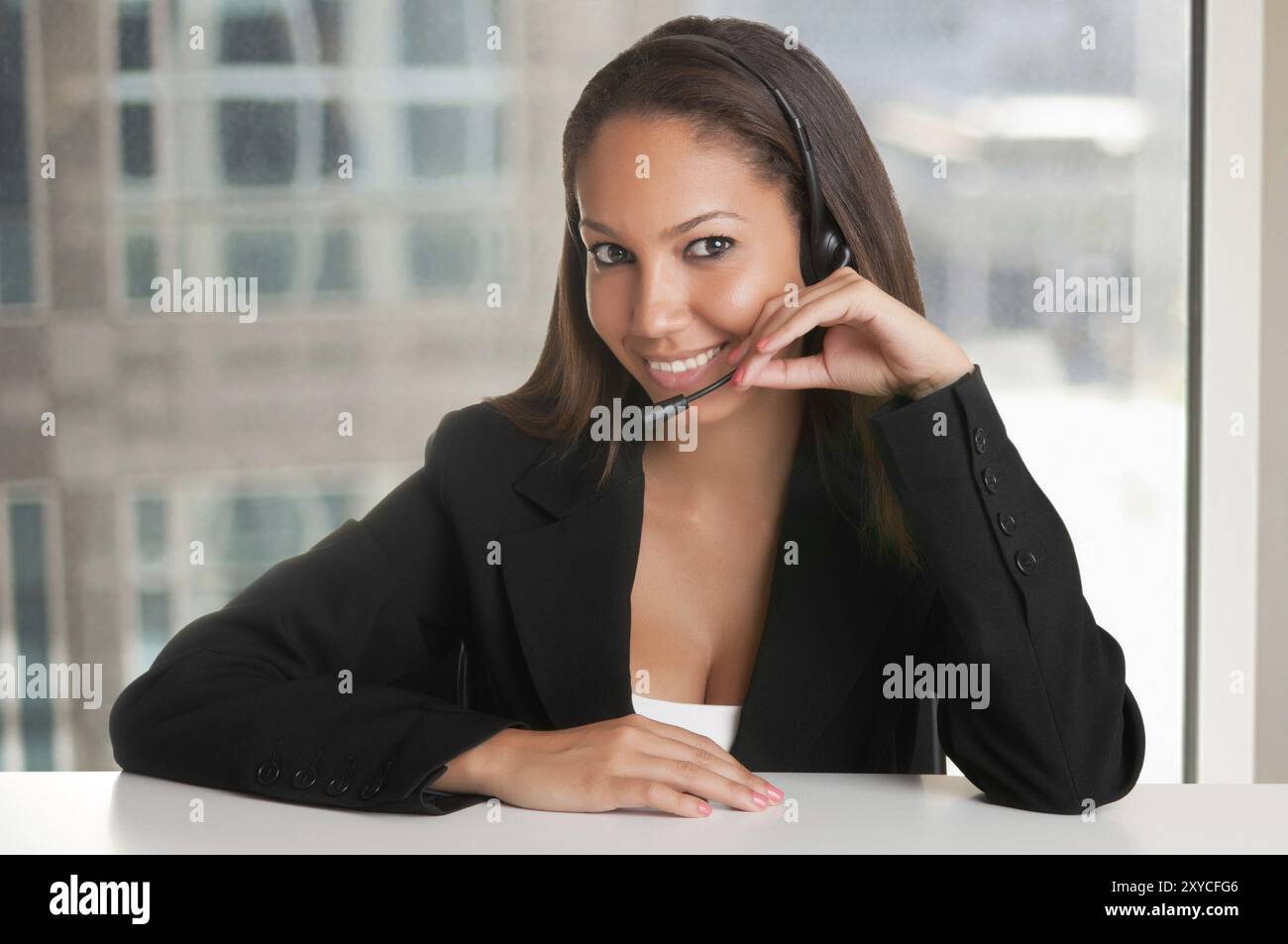 Corporate woman talking over her headset in an office Stock Photo - Alamy