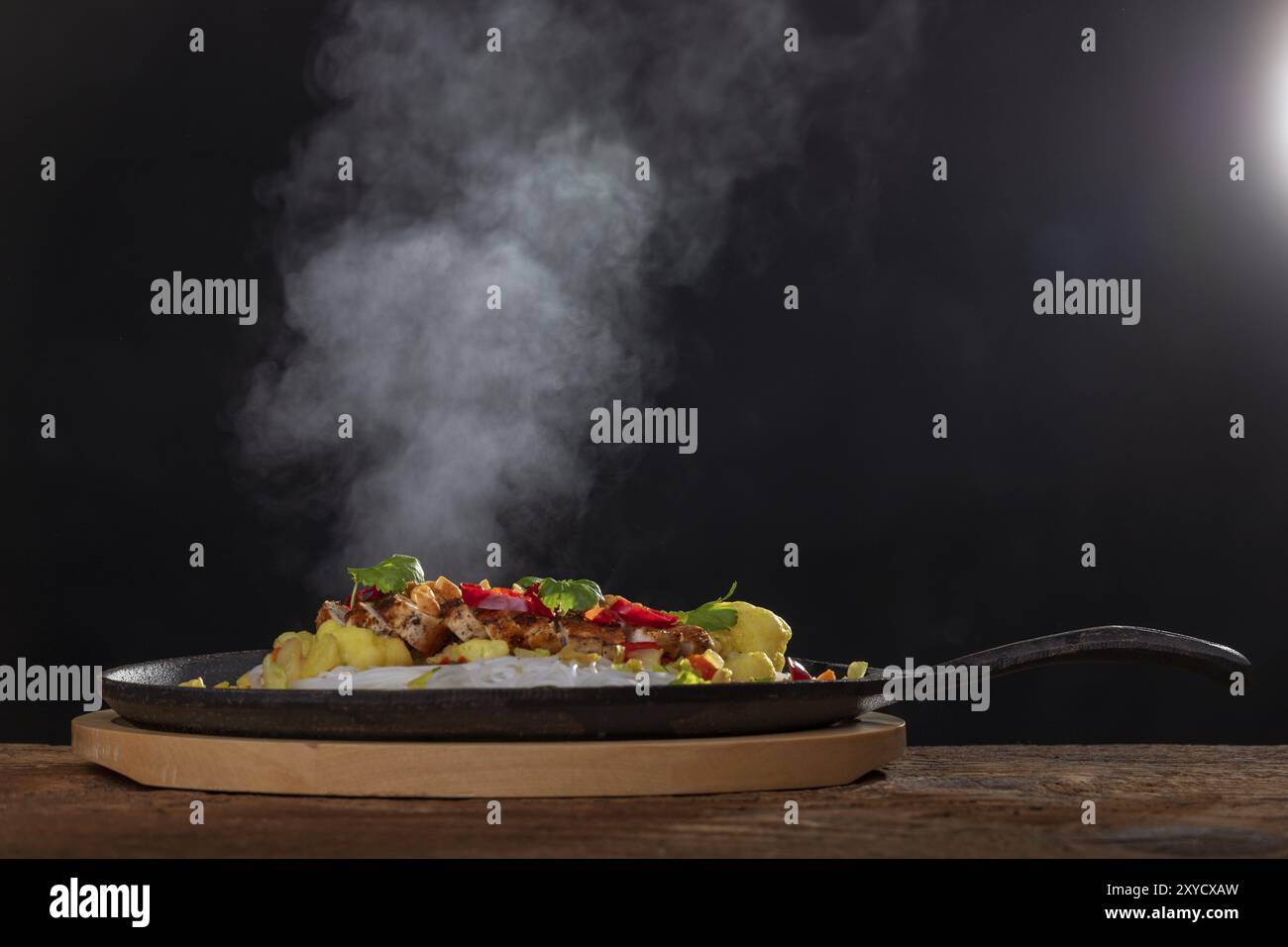 Steaming hot sizzler on wood Stock Photo - Alamy